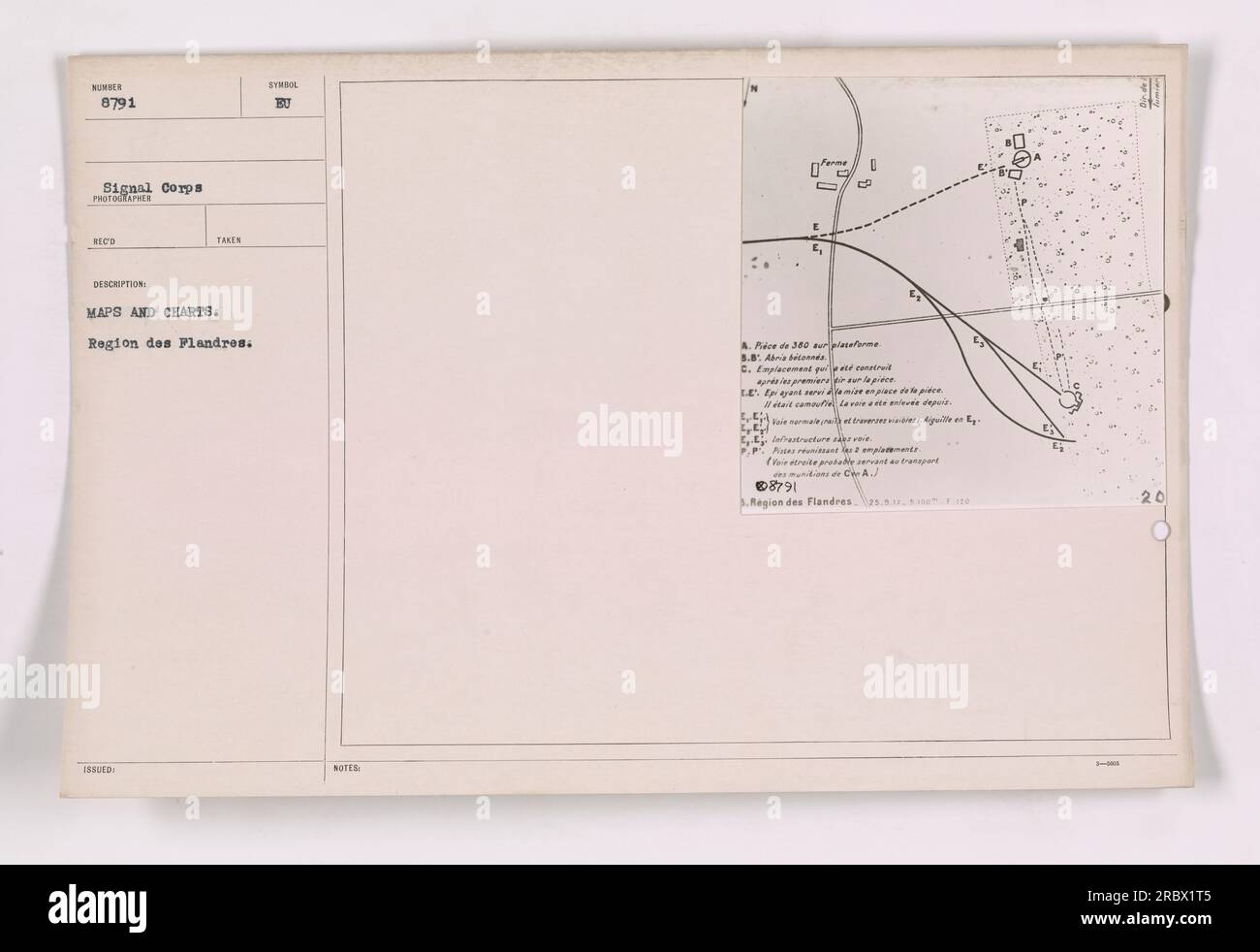A soldier examines maps and charts of the Region des Flandres during ...