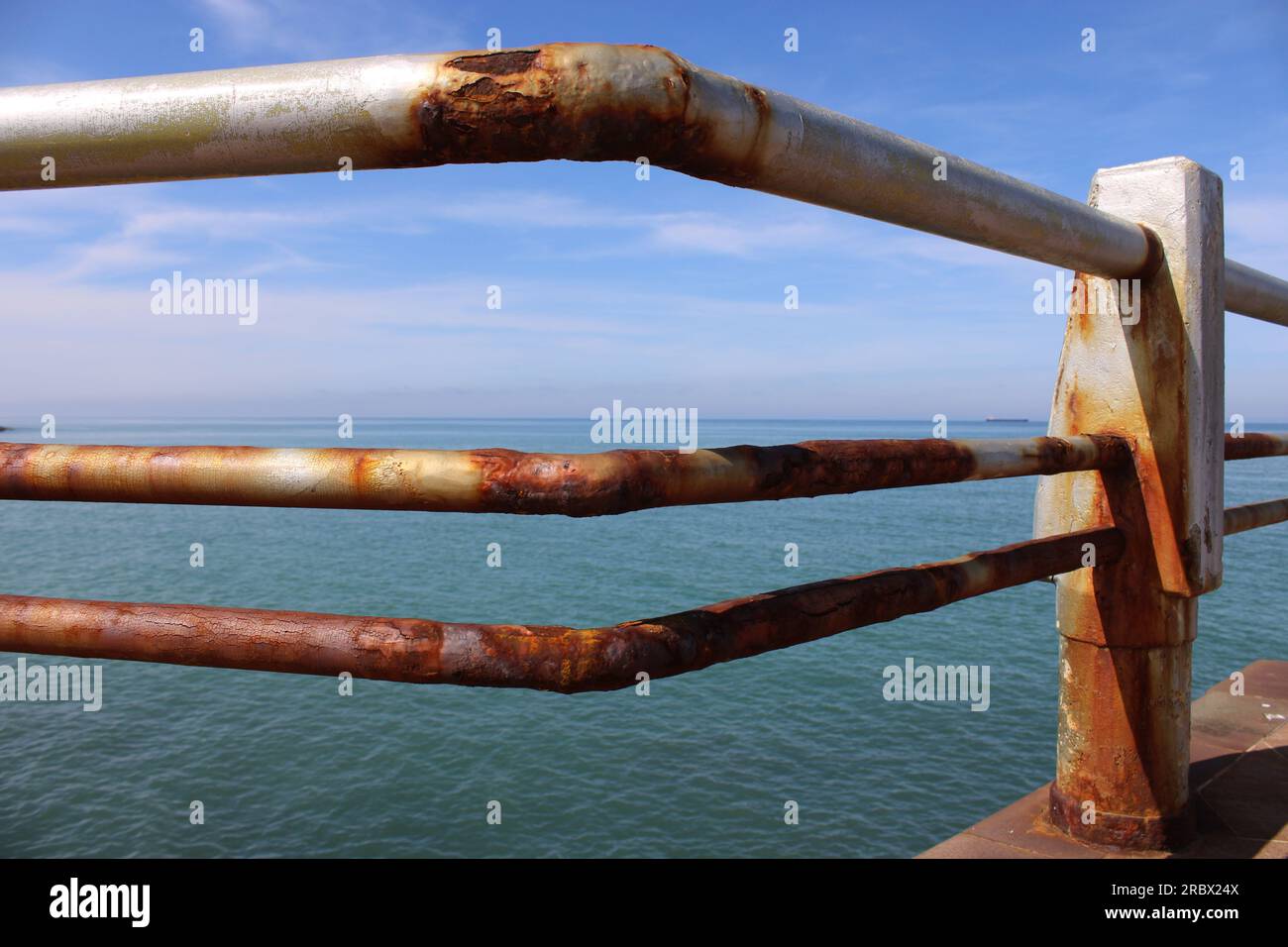 A rusty fence with a blue sea in the background.Rusty iron railing ...