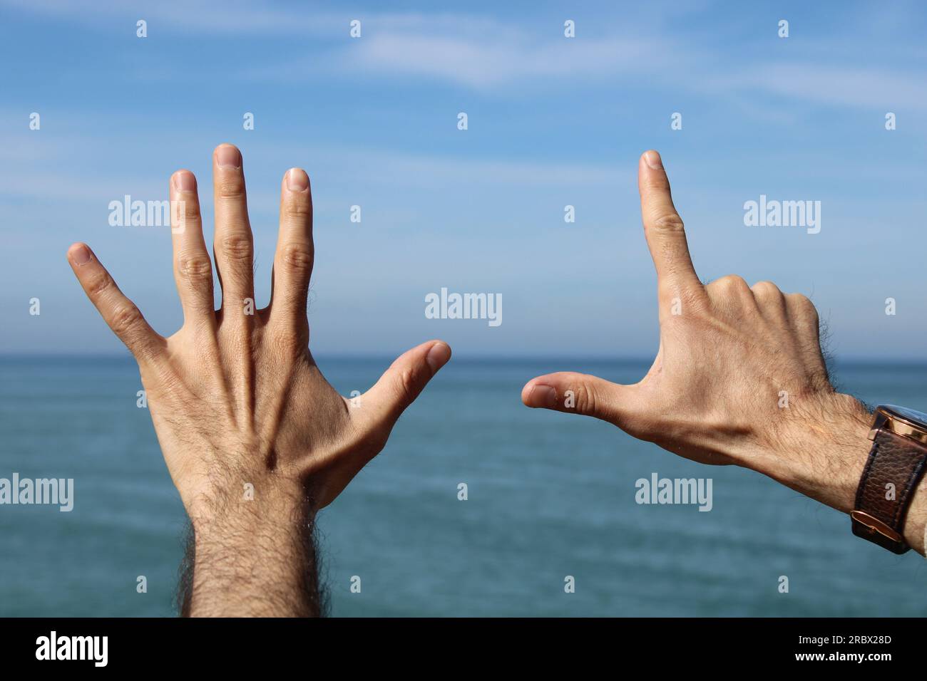 Hand doing,showing number gesture symbol seven on blue summer sky ...