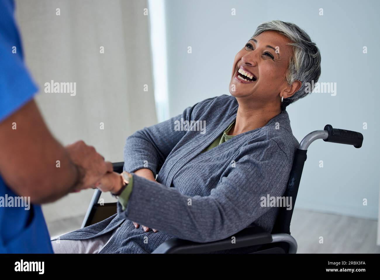 Happy woman with disability in wheelchair holding hands with nurse for ...