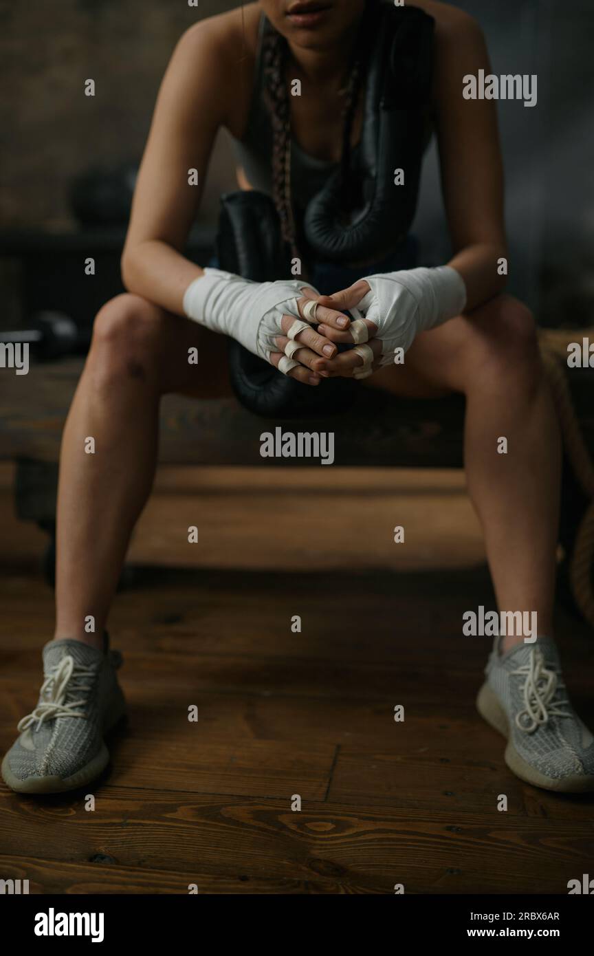 Female boxer in boxing bandage sitting on bench Stock Photo - Alamy