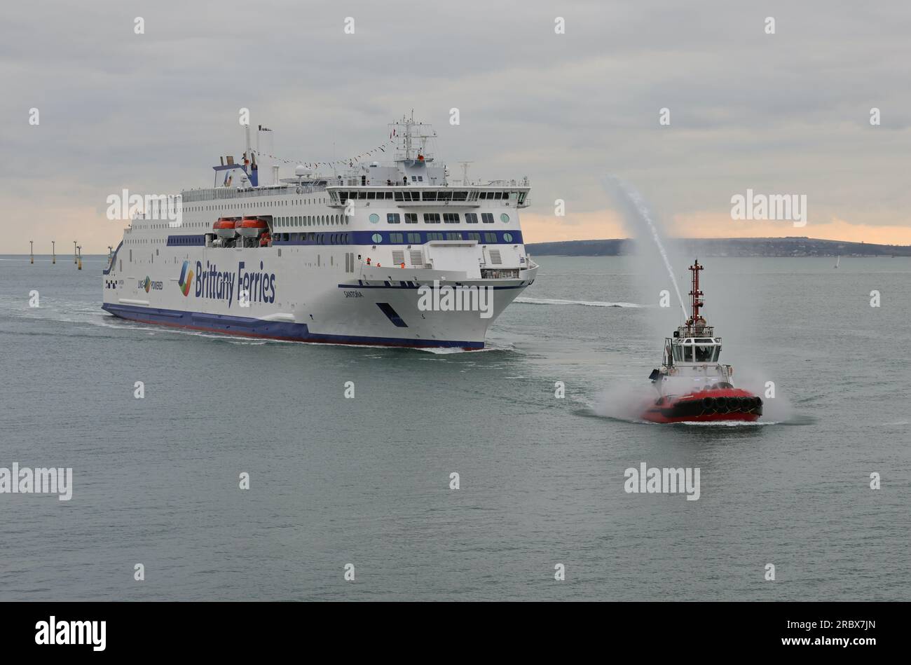 A tug sprays a water jet as it escorts the new Brittany Ferries vessel ...