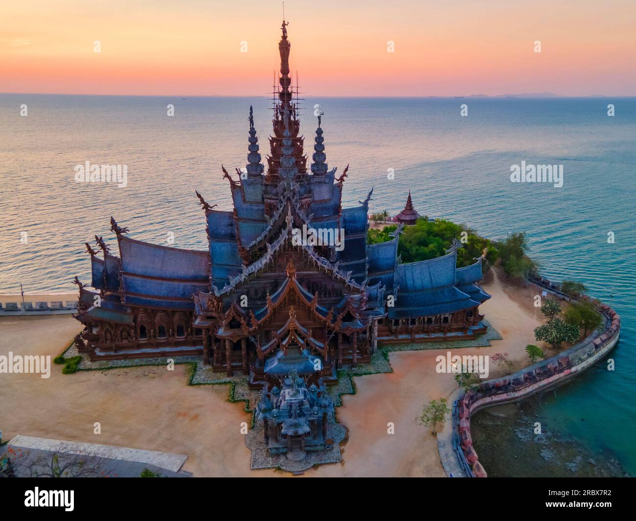 Sanctuary of Truth, Pattaya, Thailand, wooden temple by the ocean during sunset on the beach of ...