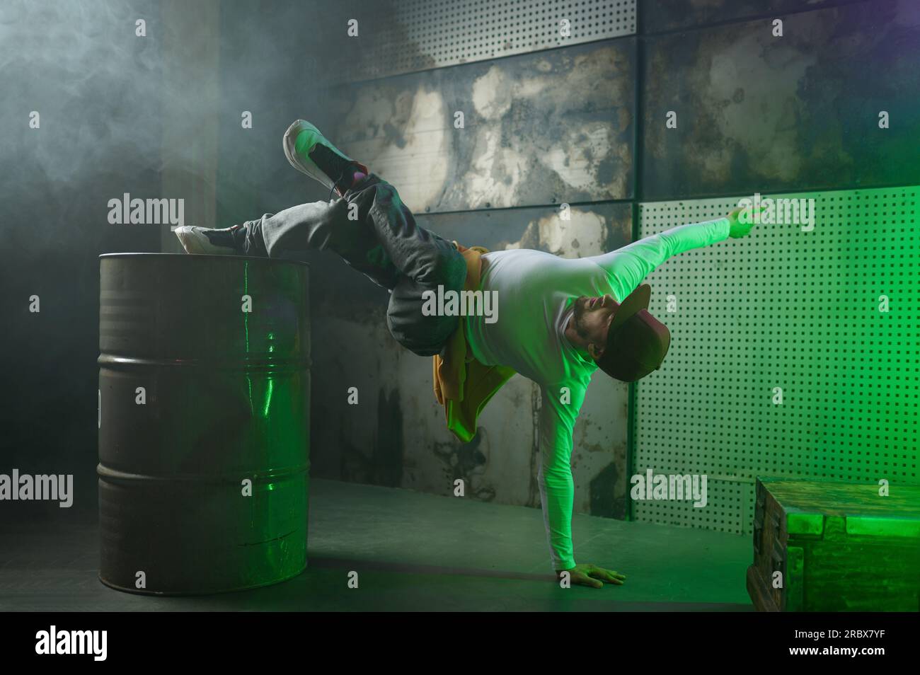Male break dancer performing on loft stage in green neon light Stock ...