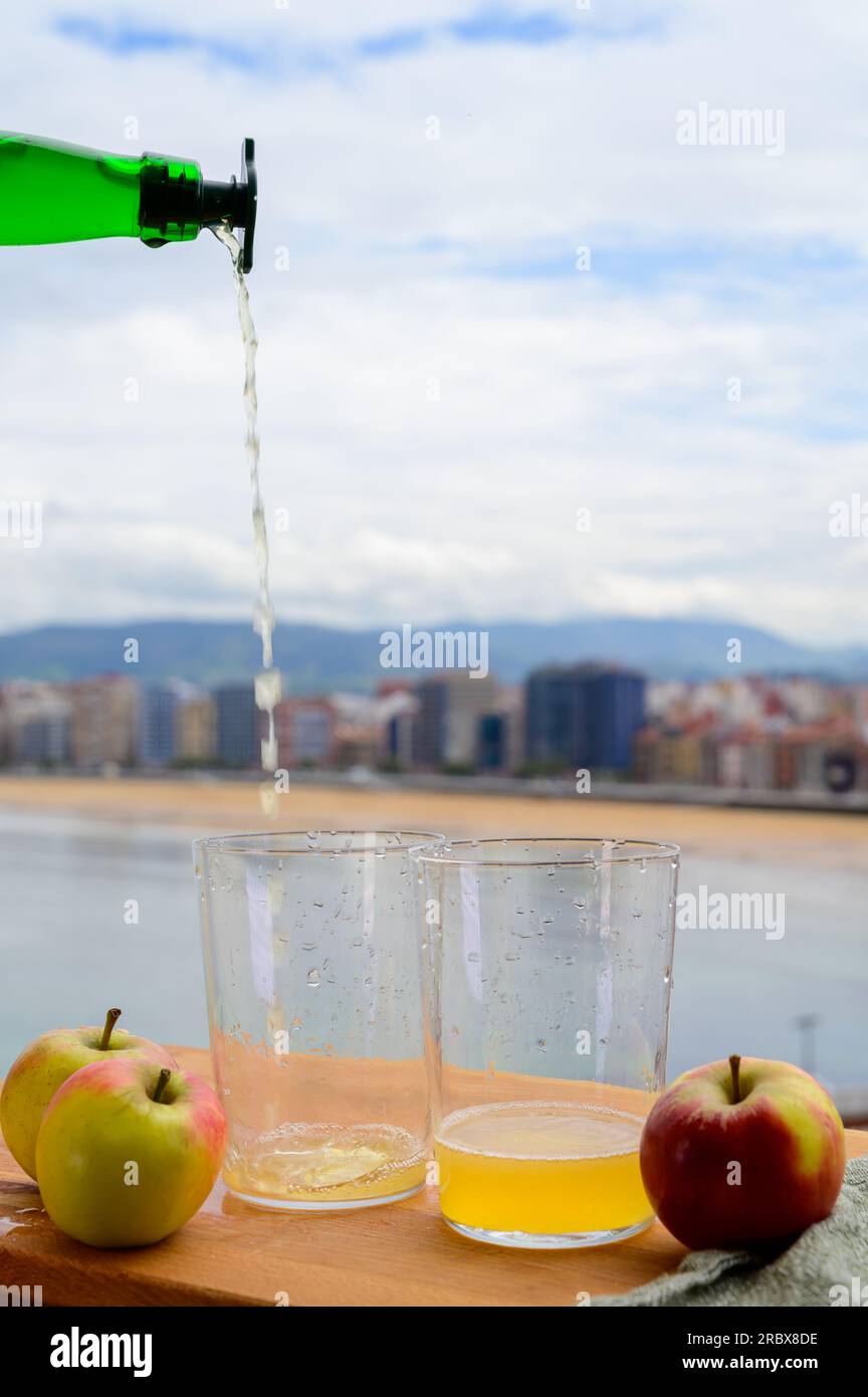 Pouring of natural Asturian cider made from fermented apples in wooden ...