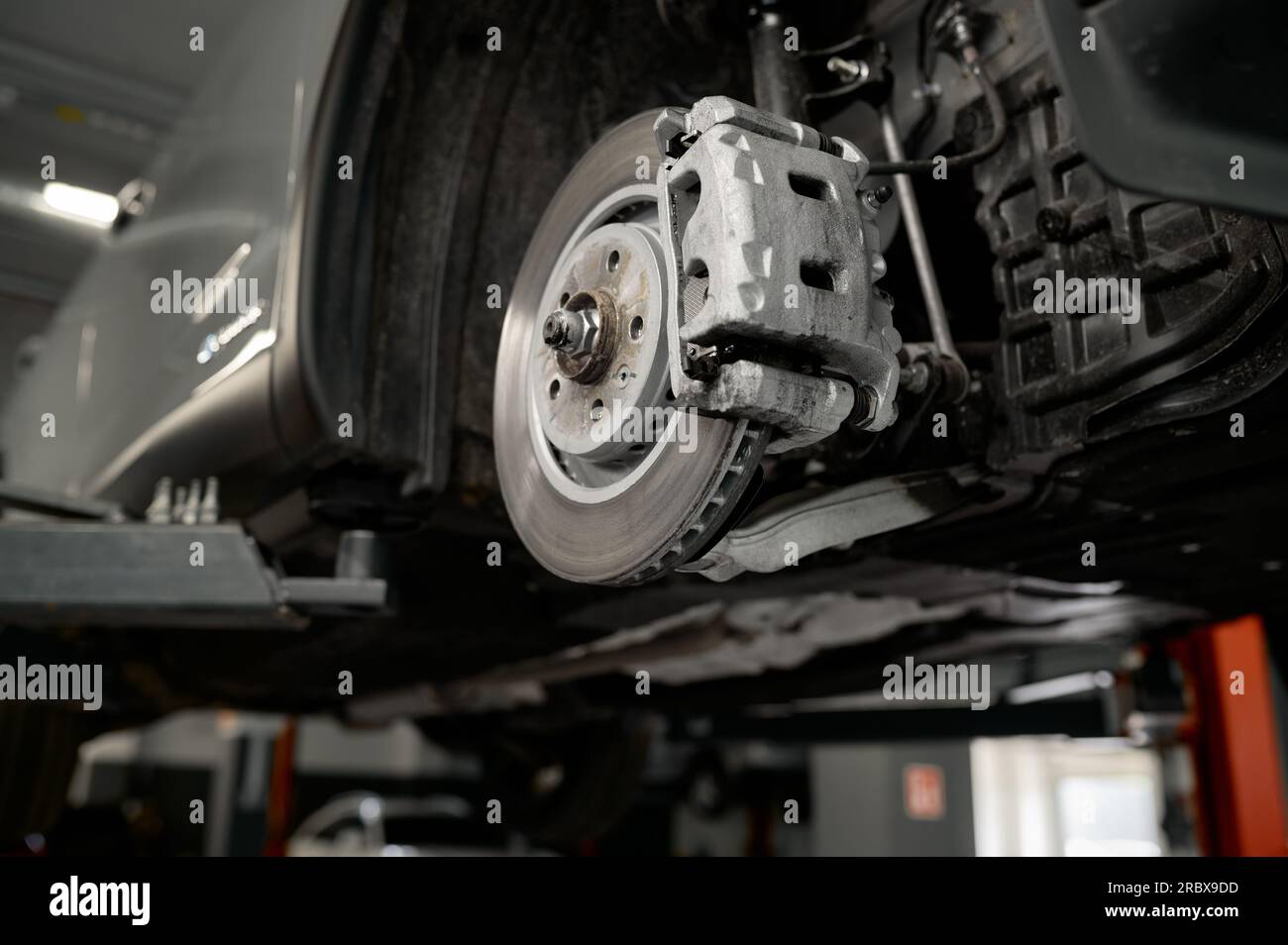 Closeup wheel hub of raised car on lift mechanism at garage auto ...