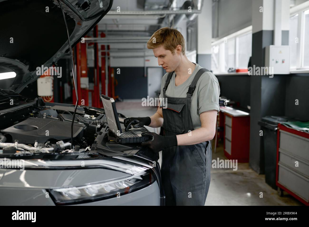 Mechanic providing computer diagnostics to find cause of car failure ...