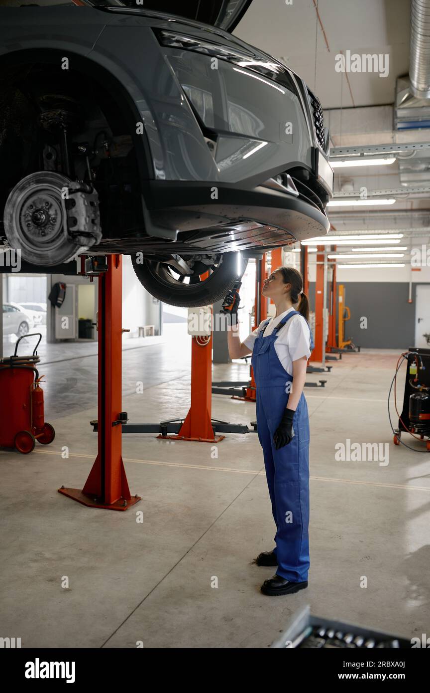 Mechanic inspecting suspended vehicle hi-res stock photography and ...