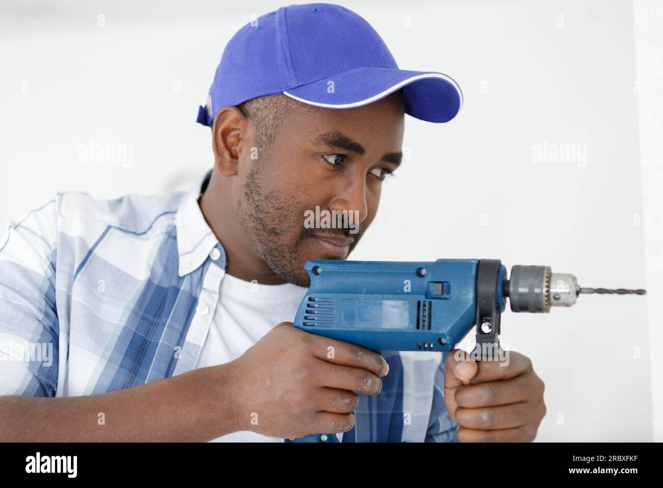 manual worker drilling a hole on a wall Stock Photo - Alamy