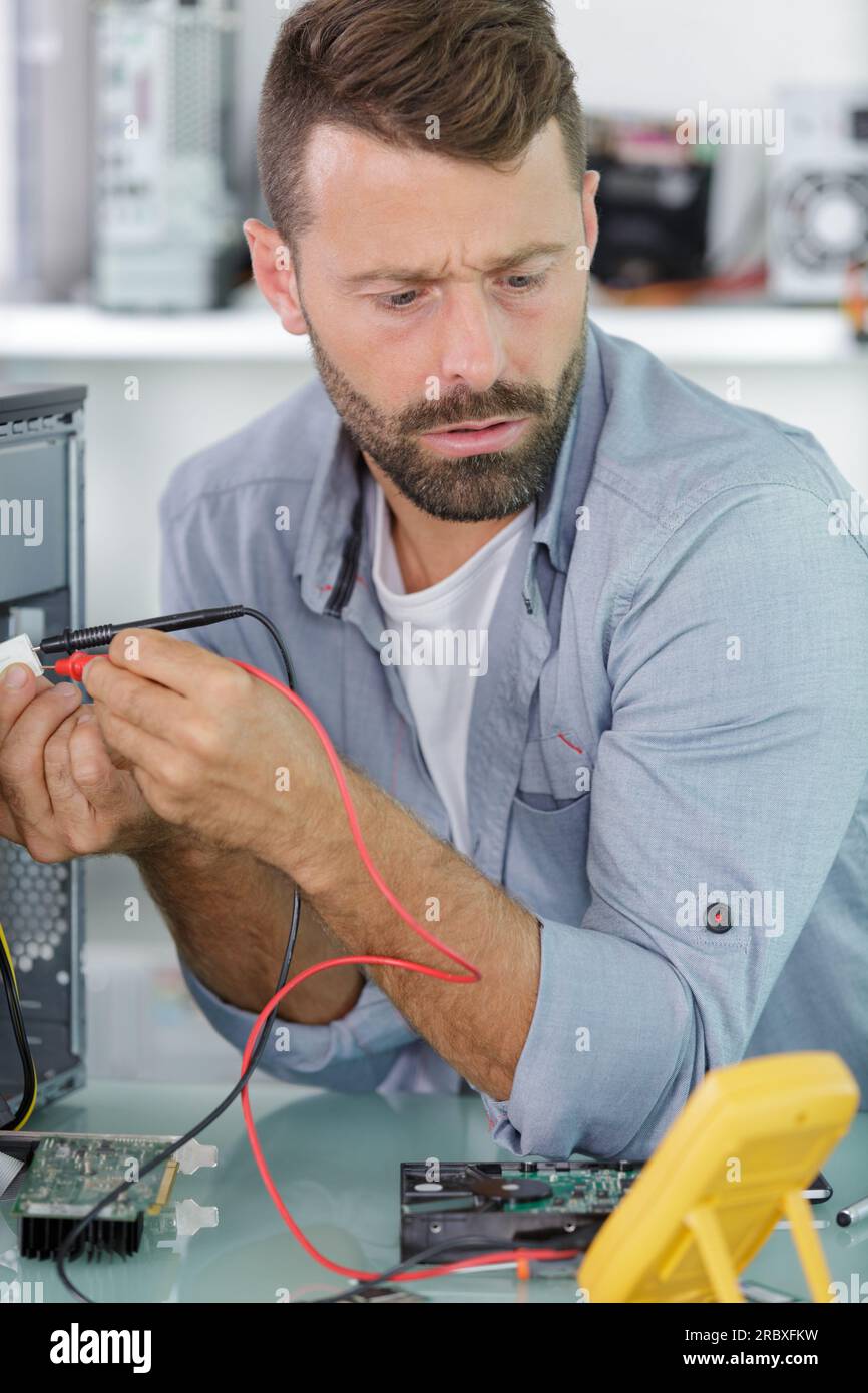 man checking computer with a multimeter Stock Photo - Alamy