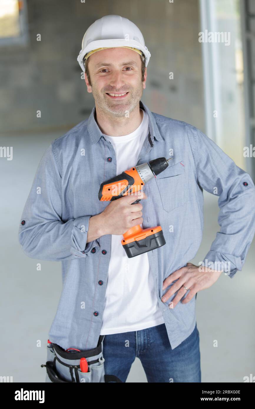 handyman holding a drill machine Stock Photo - Alamy