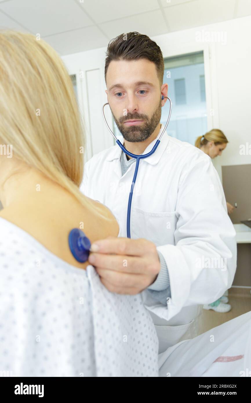 Woman doctor uses stethoscope listen hi-res stock photography and ...