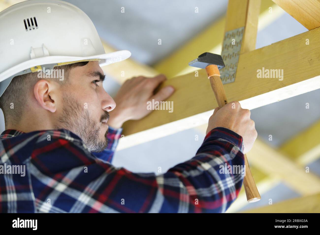 carpenter working on roof structure at construction site Stock Photo ...