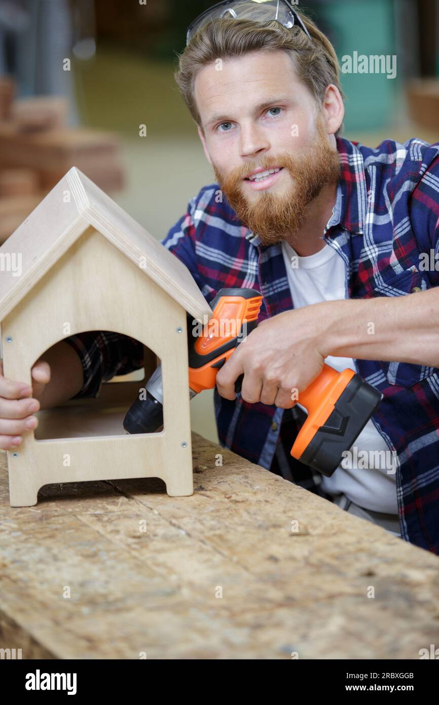 man with wood plank at workshop making a house model Stock Photo - Alamy