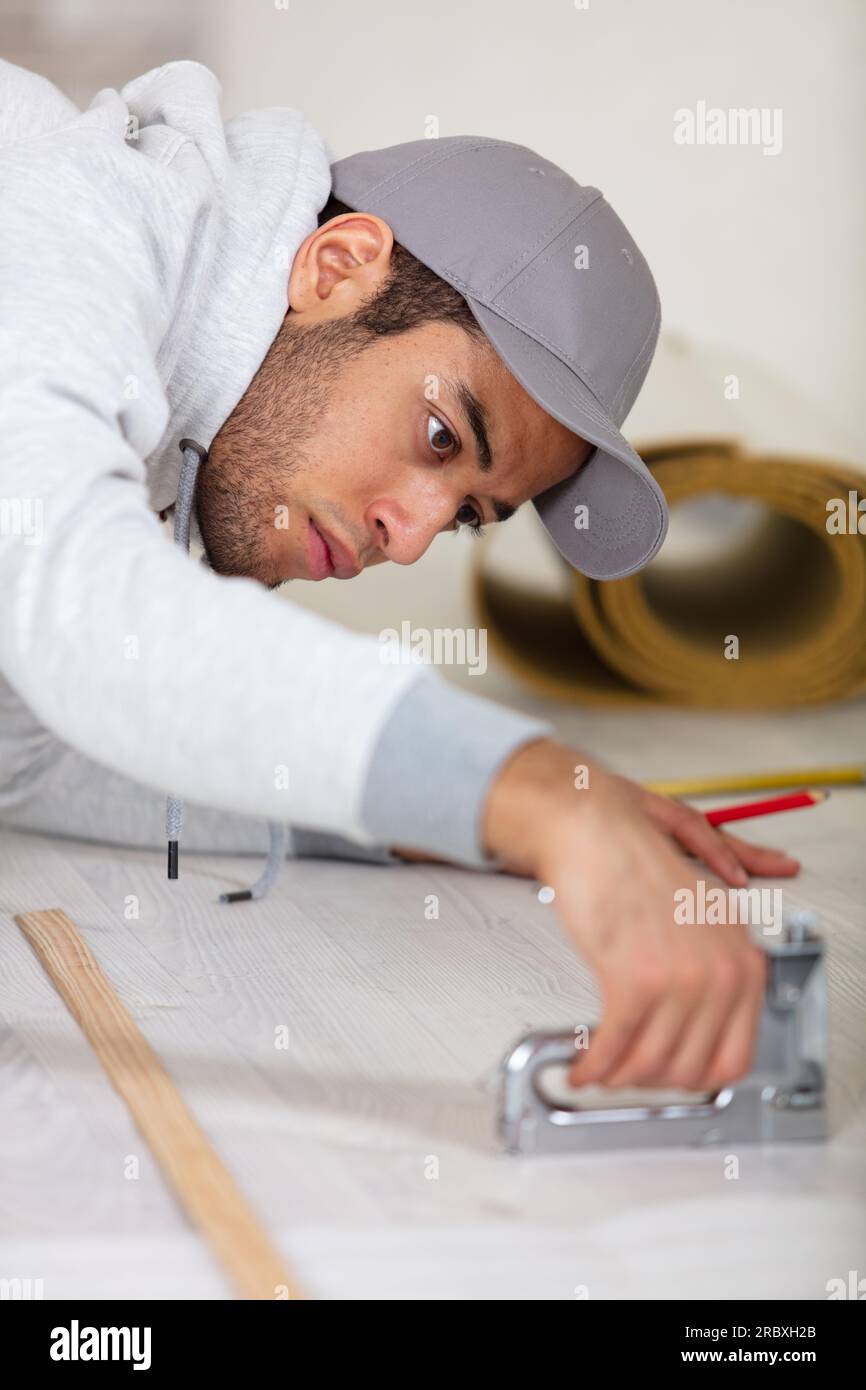 young handyman installing wooden floor in new house Stock Photo - Alamy