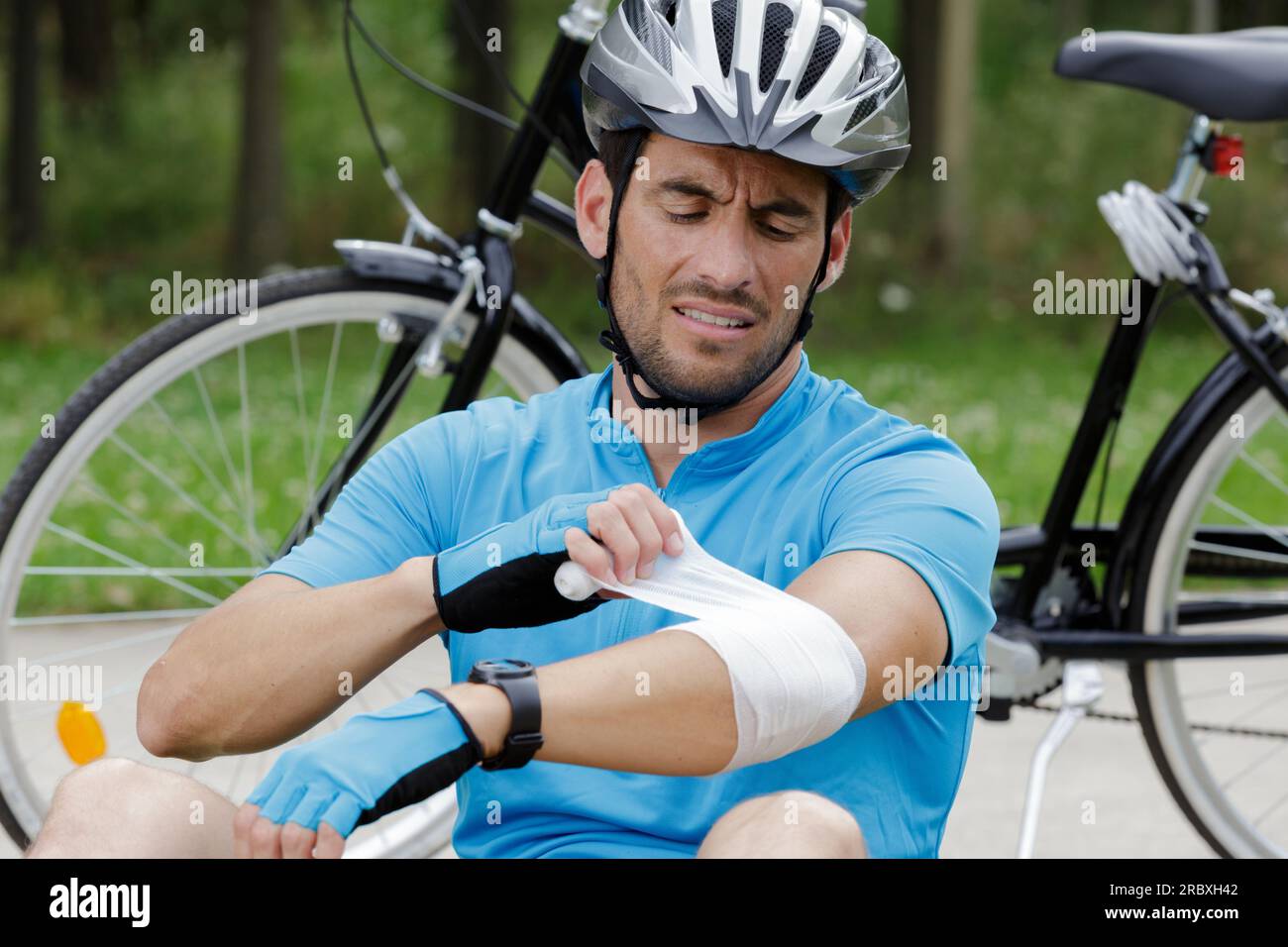 male cyclist wrapping his injured elbow Stock Photo - Alamy