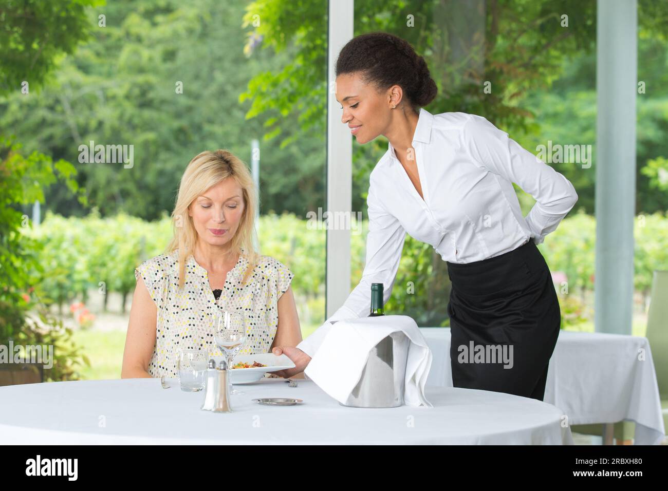 she is serving the guest Stock Photo - Alamy