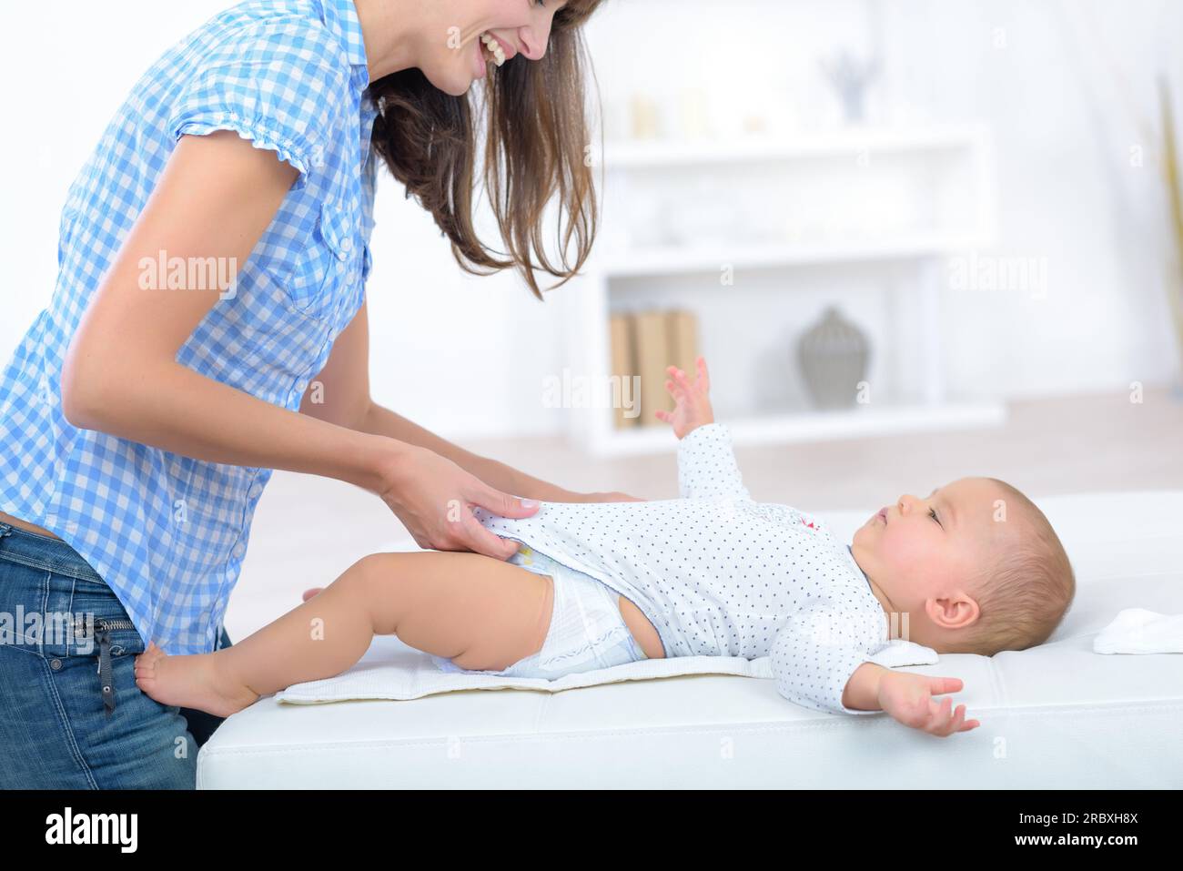 mother dressing baby after changing nappy Stock Photo - Alamy