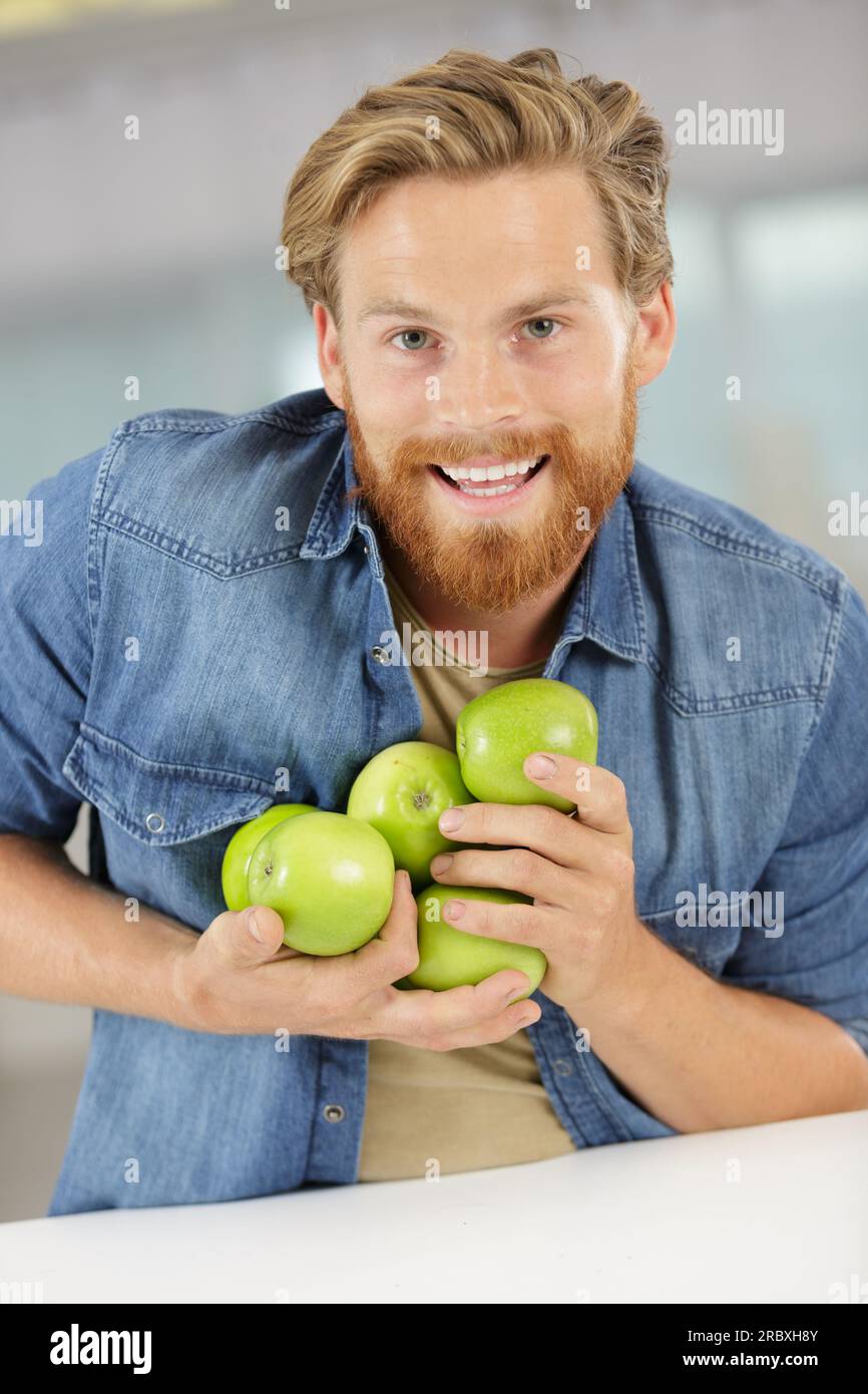 portrait of cheerful young man holding apples Stock Photo - Alamy