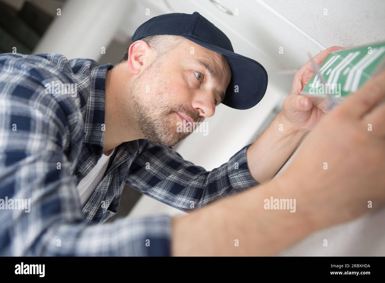 man fixing illuminated exit sign to wall Stock Photo - Alamy