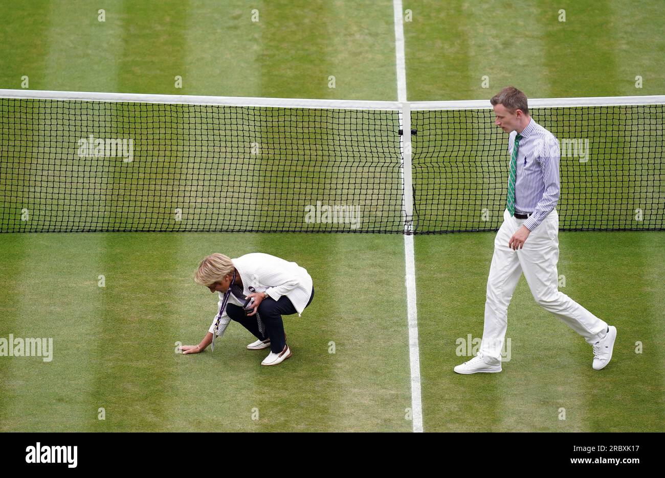 The match referee checks on the playing surface as rain stops play on ...