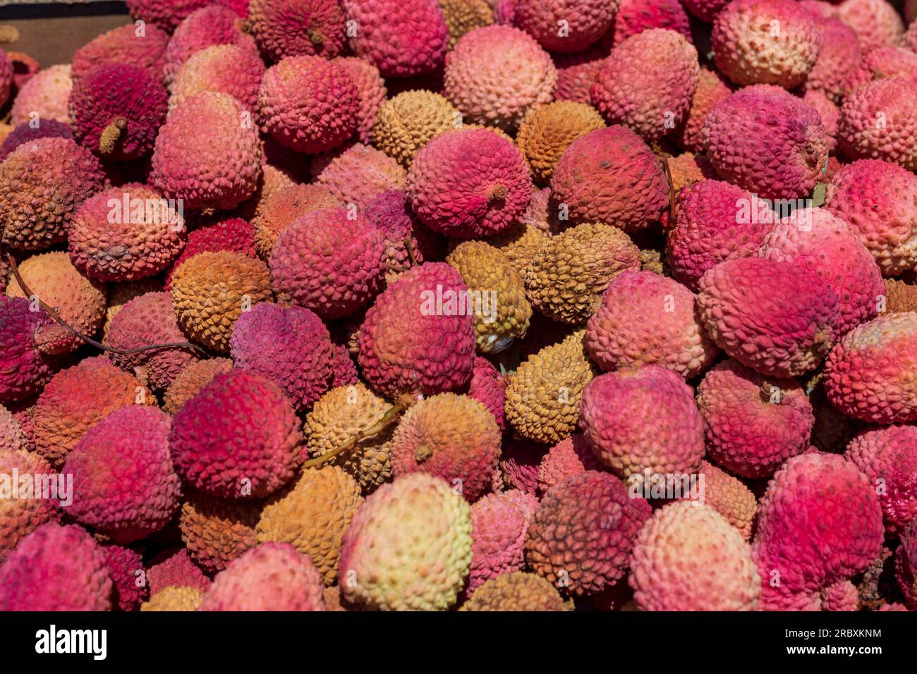 Pink lychee in a willow wicker basket for sale on a counter in Borough ...