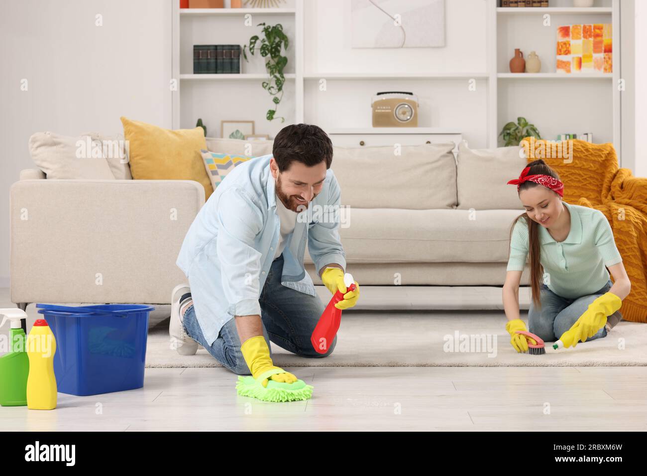 Spring cleaning. Couple tidying up living room together Stock Photo - Alamy
