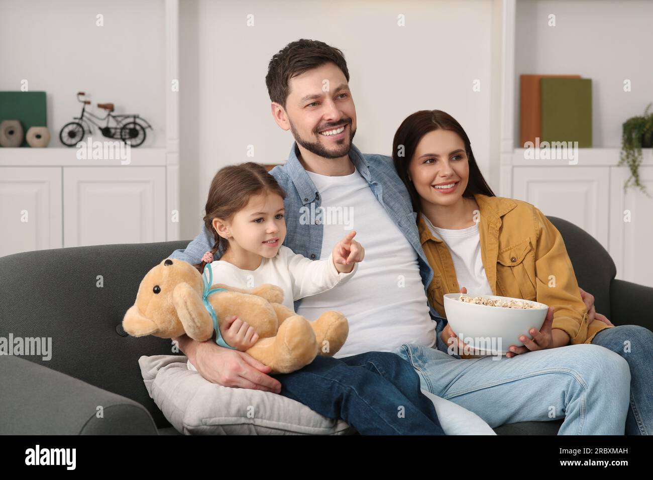 Happy family watching movie via TV at home Stock Photo - Alamy