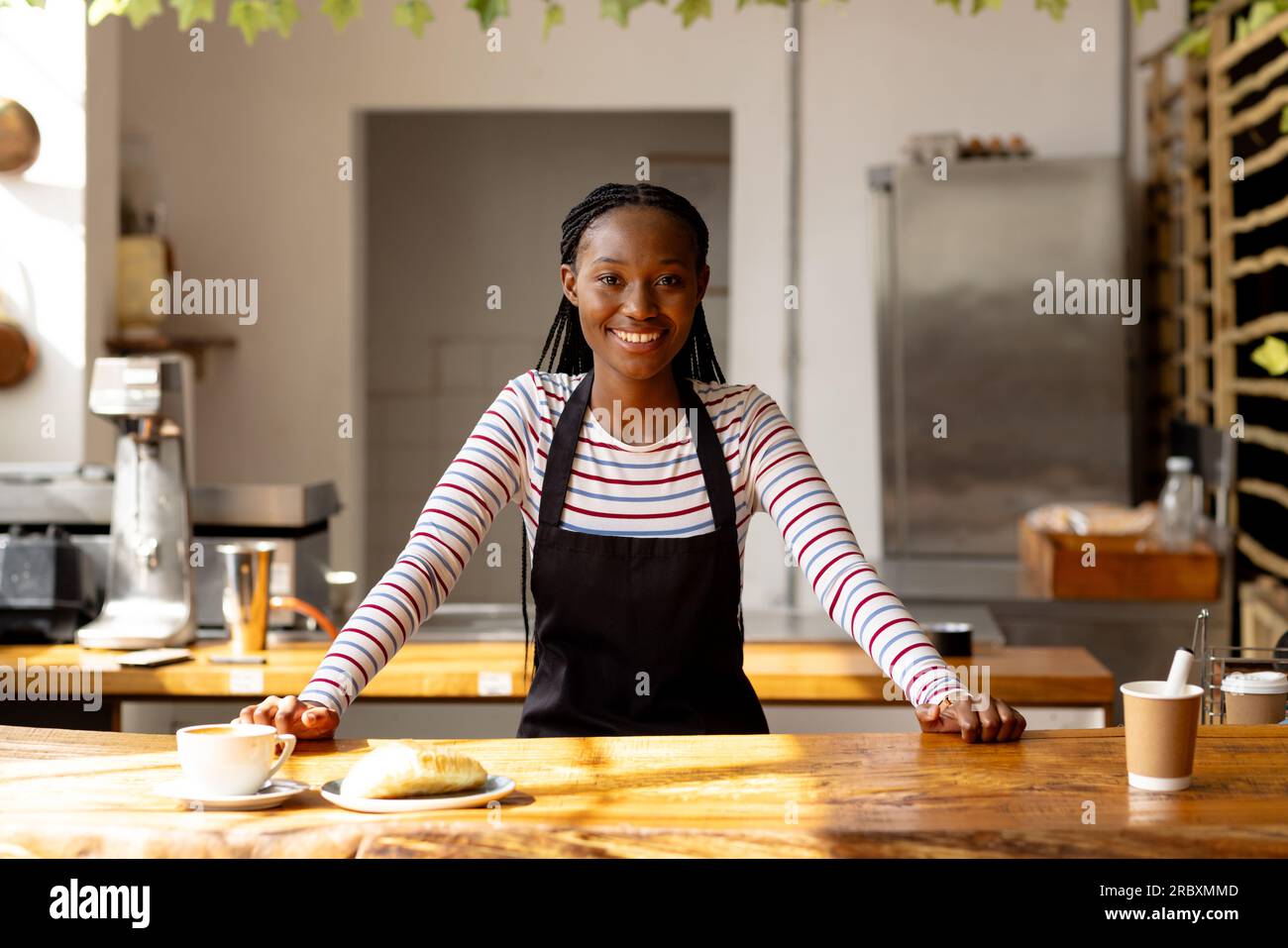 Portrait of happy african american female cafe owner in apron staying ...