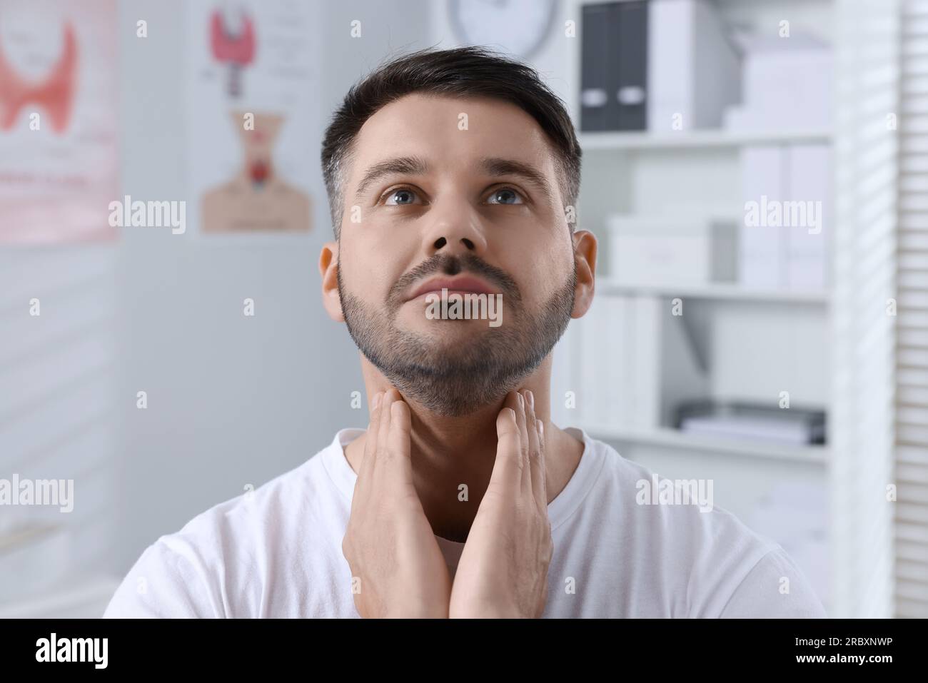 Endocrine system. Man doing thyroid self examination indoors Stock ...