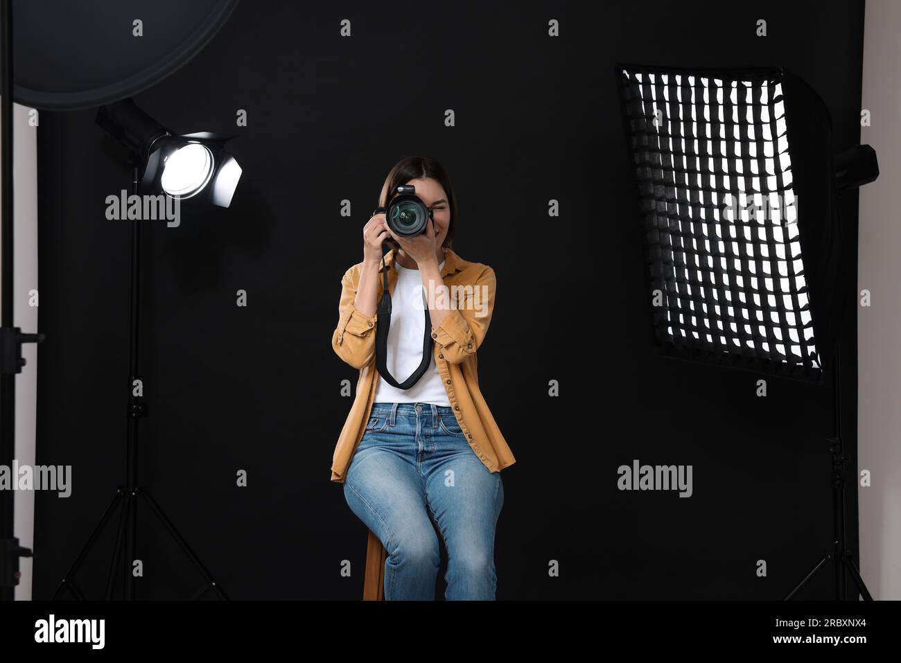 Professional photographer taking picture in modern photo studio Stock ...