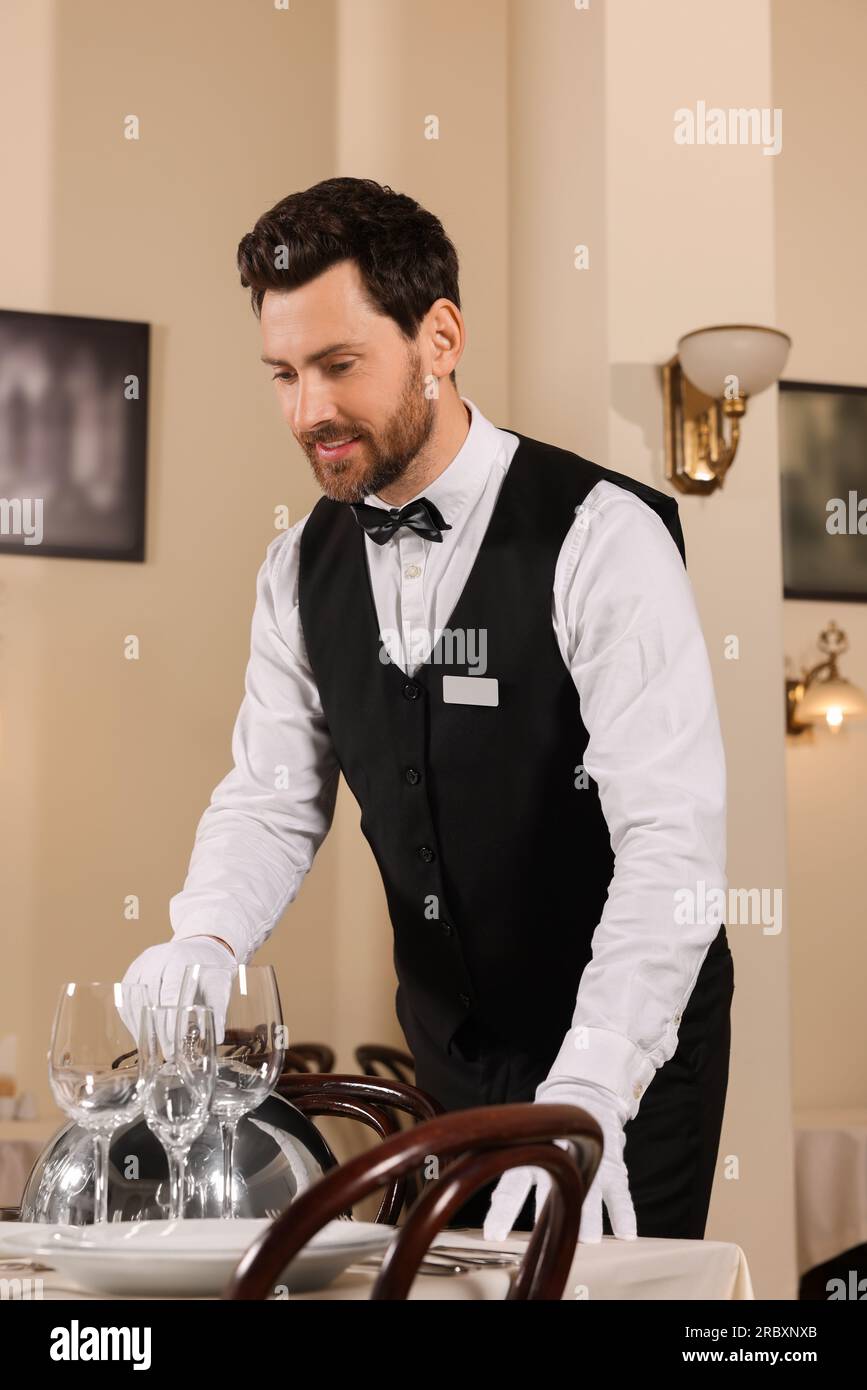 Man setting table in restaurant. Professional butler courses Stock ...