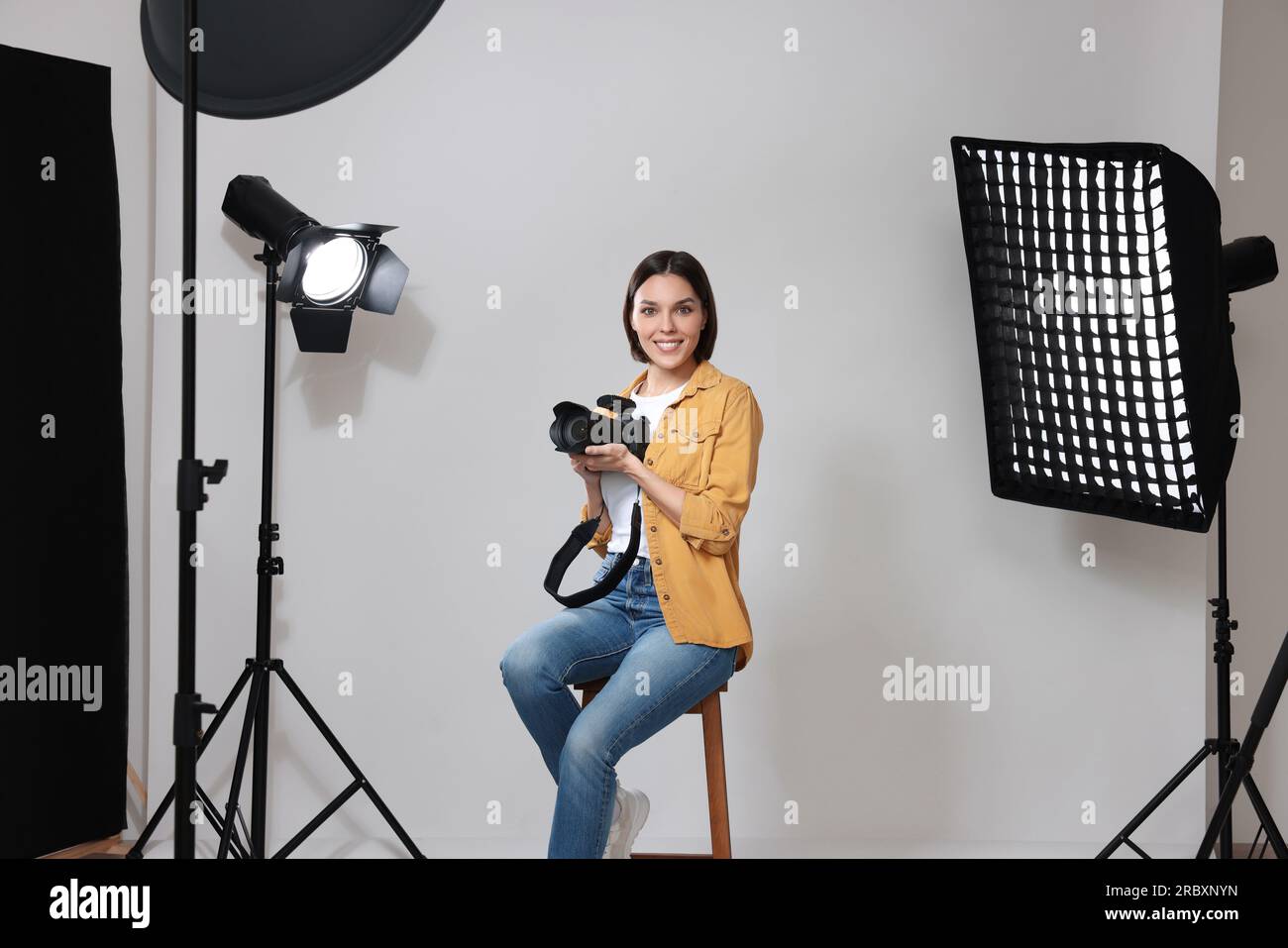 Professional photographer with camera in modern photo studio Stock ...