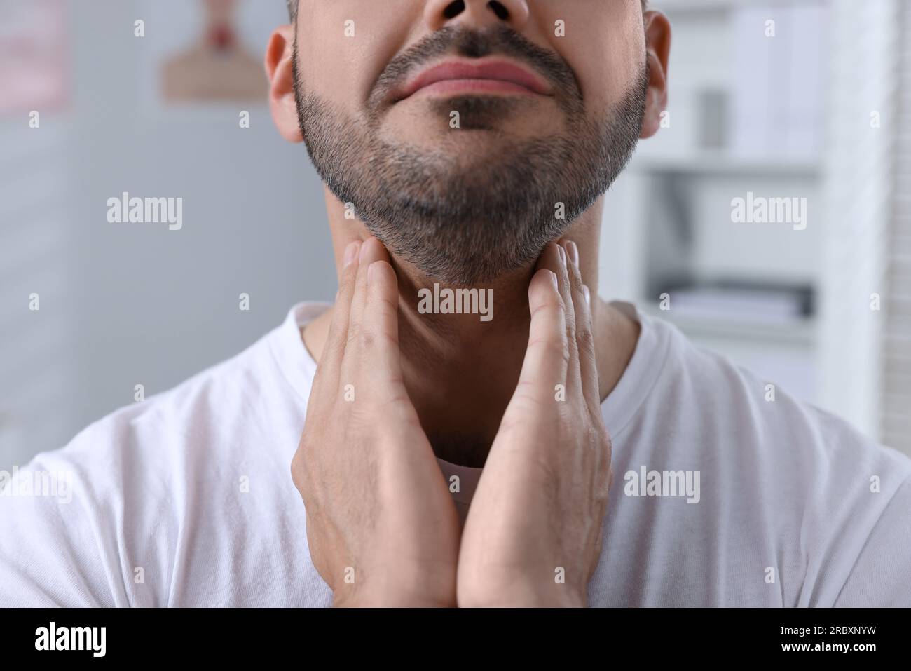 Endocrine system. Man doing thyroid self examination indoors, closeup ...