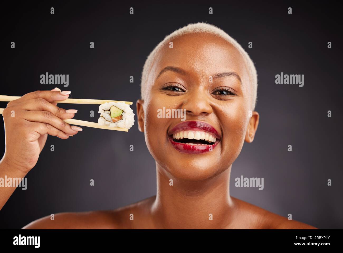 Face, woman and sushi with chopsticks in studio for healthy eating ...