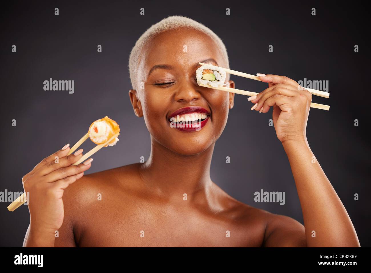 Sushi, face and woman with chopsticks in studio for healthy eating ...