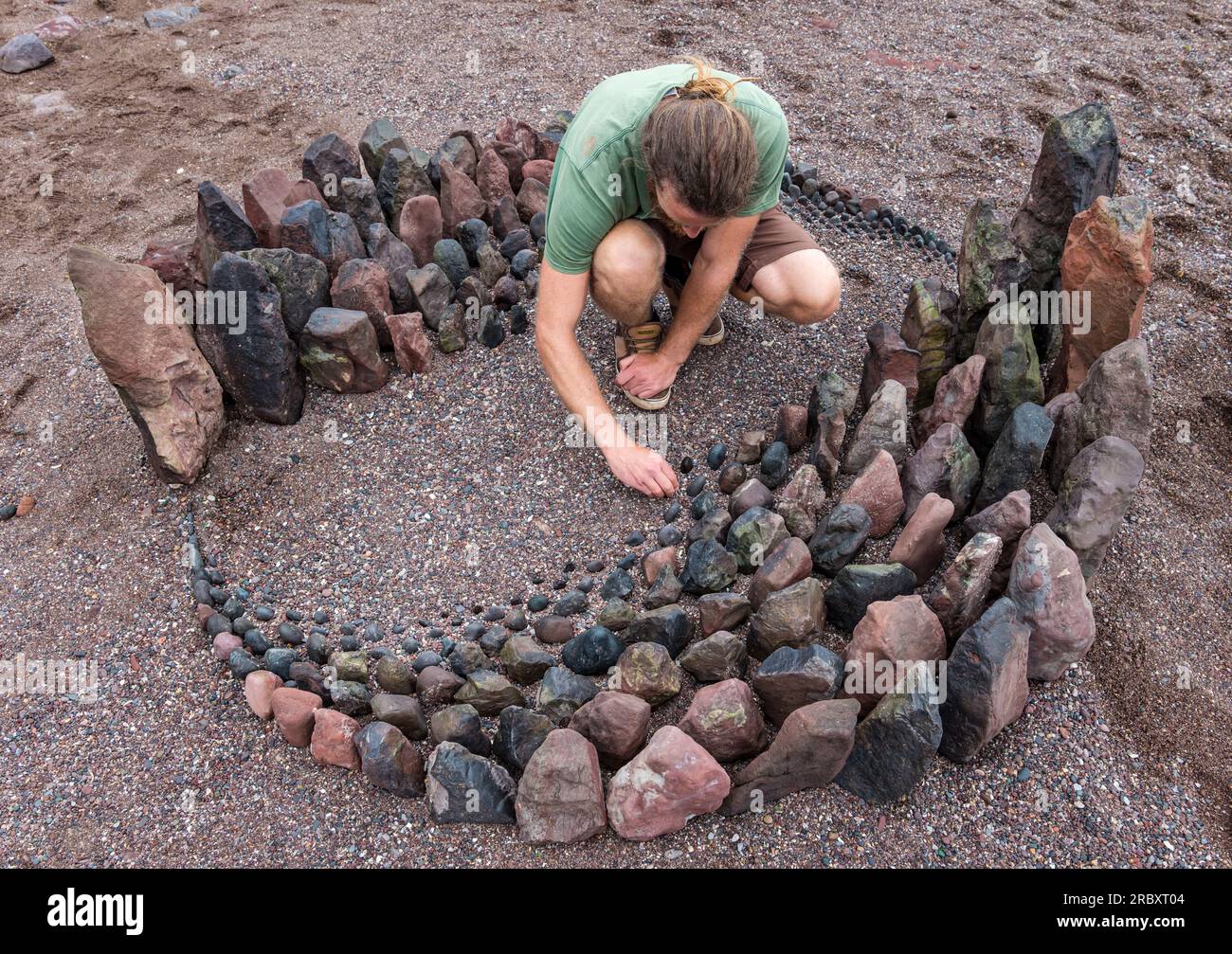 Land artist Jon Foreman creates a rock or stone sculpture, European ...