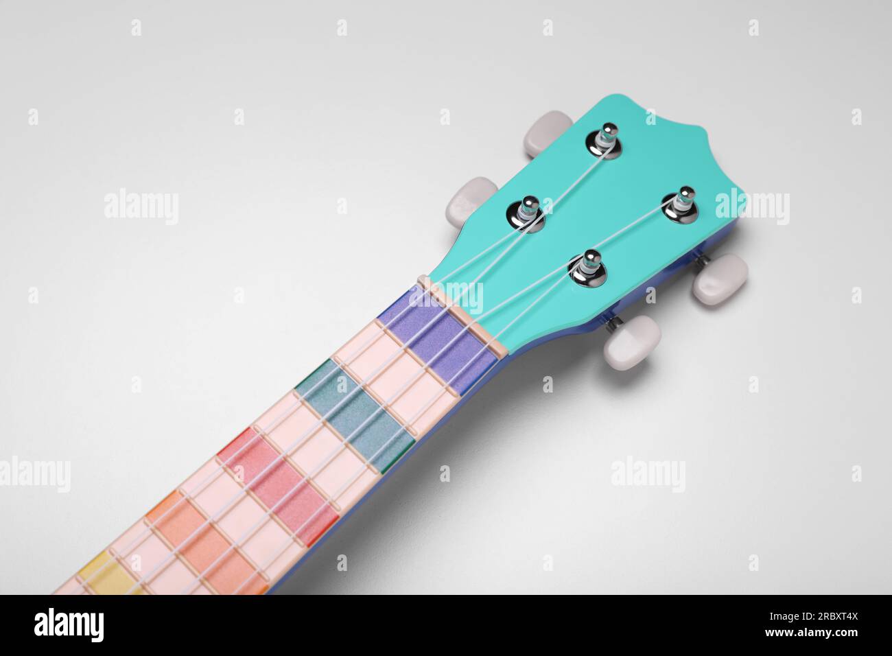 Colorful ukulele neck on white background, above view. String musical ...