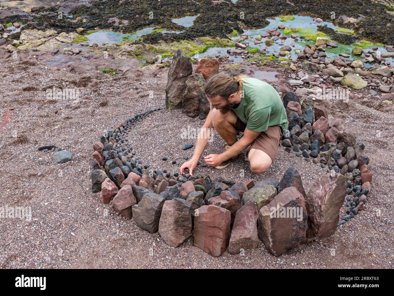 Land artist Jon Foreman creates a rock or stone sculpture, European ...