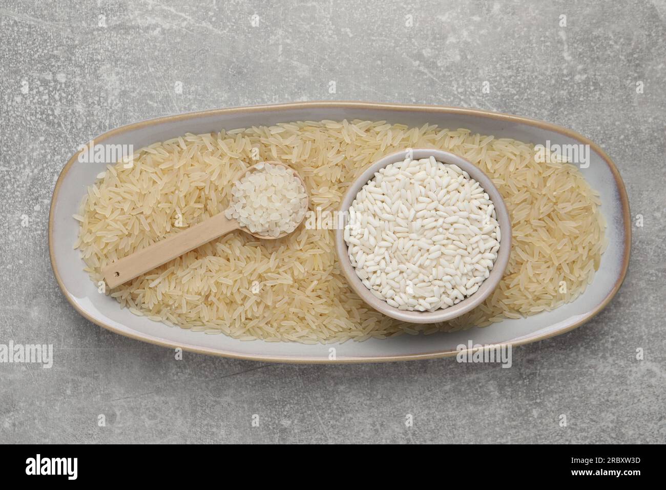 Different sorts of rice on grey table, top view Stock Photo - Alamy