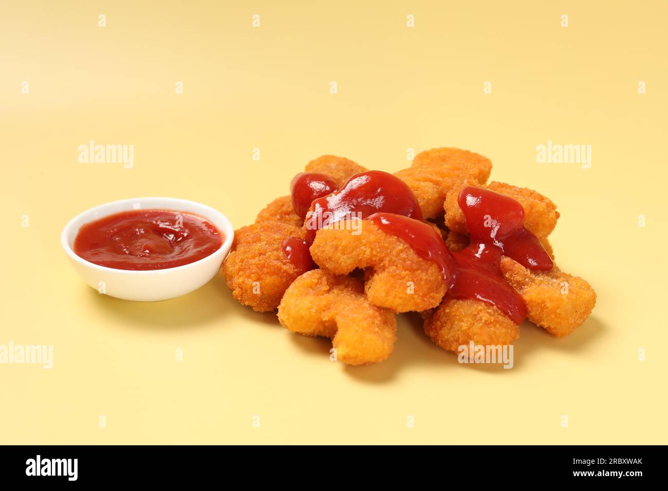 Tasty chicken nuggets with ketchup on pale yellow background Stock ...