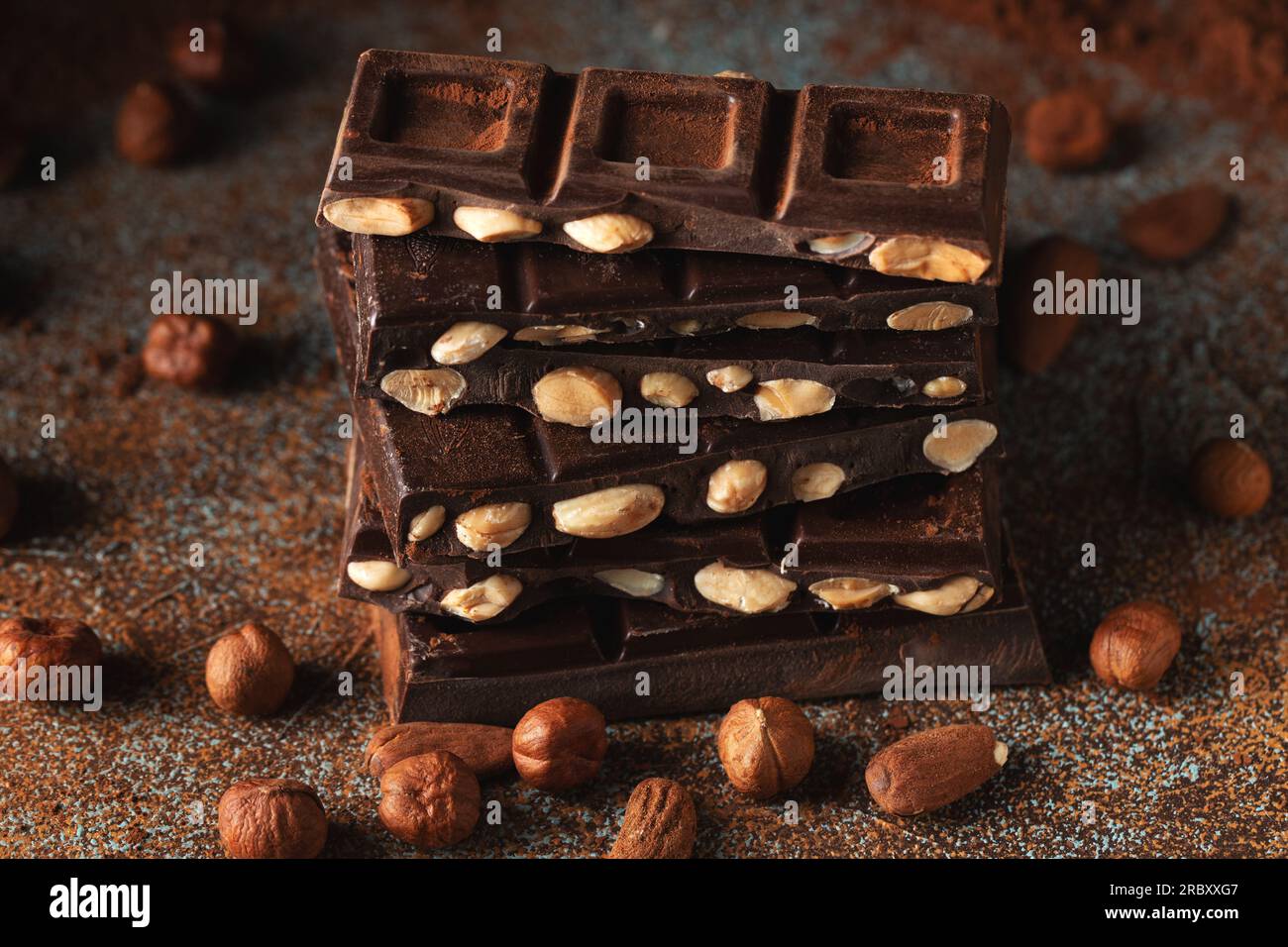 Dark and milk chocolate with nuts on a dark background sprinkled with ...
