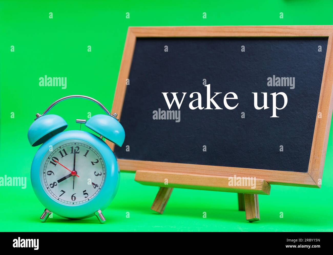 Chalkboard message to wake up with alarm clock on green background ...