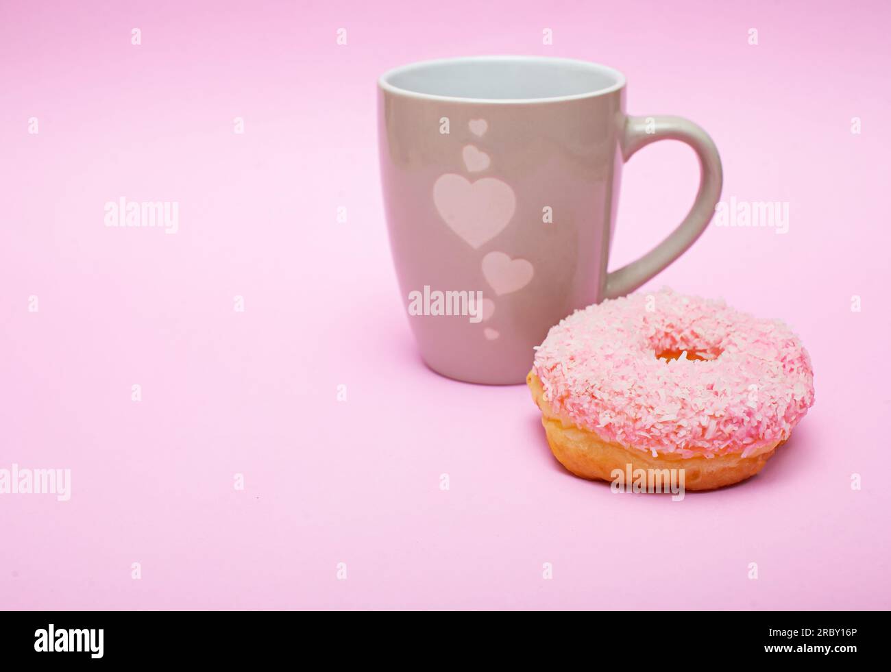 pink glazed donuts and a cup of coffee on pink background and pink wall ...