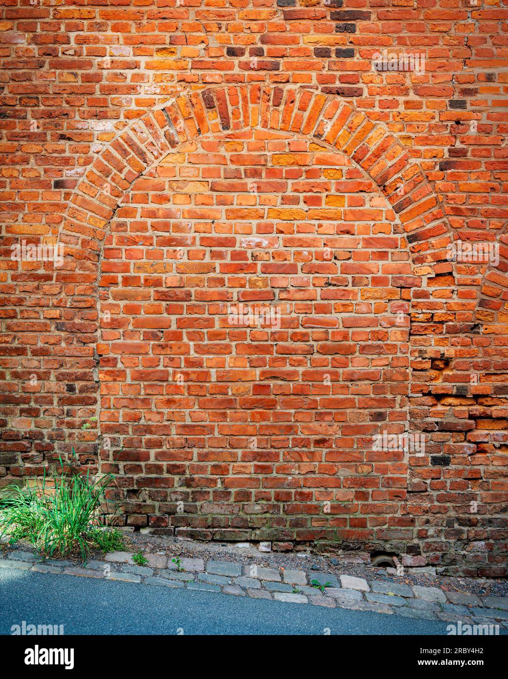 A bricked up doorway arch on the side of an old factory building Stock ...