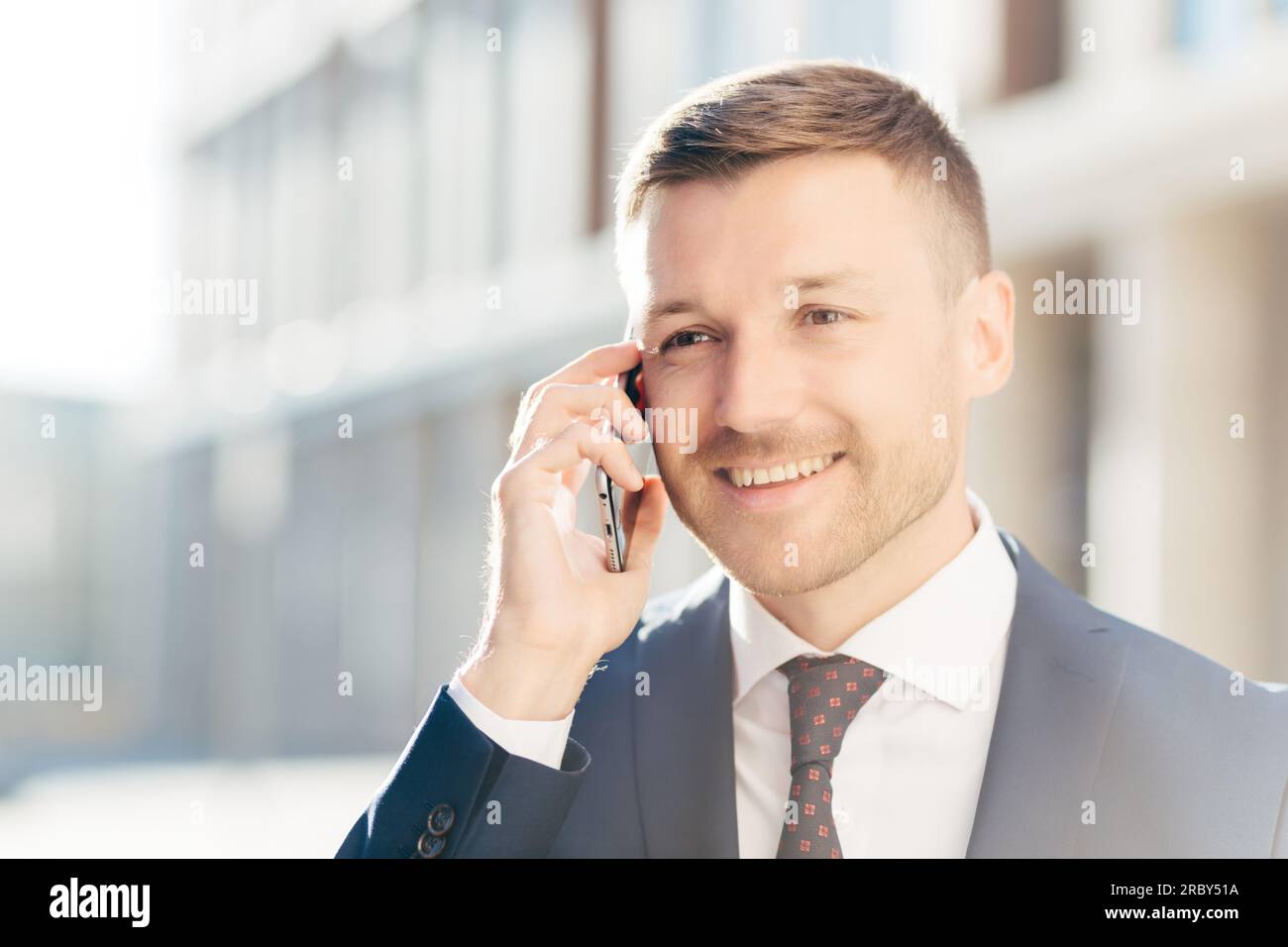 Confident happy middle aged businessman communicates via cell phone ...