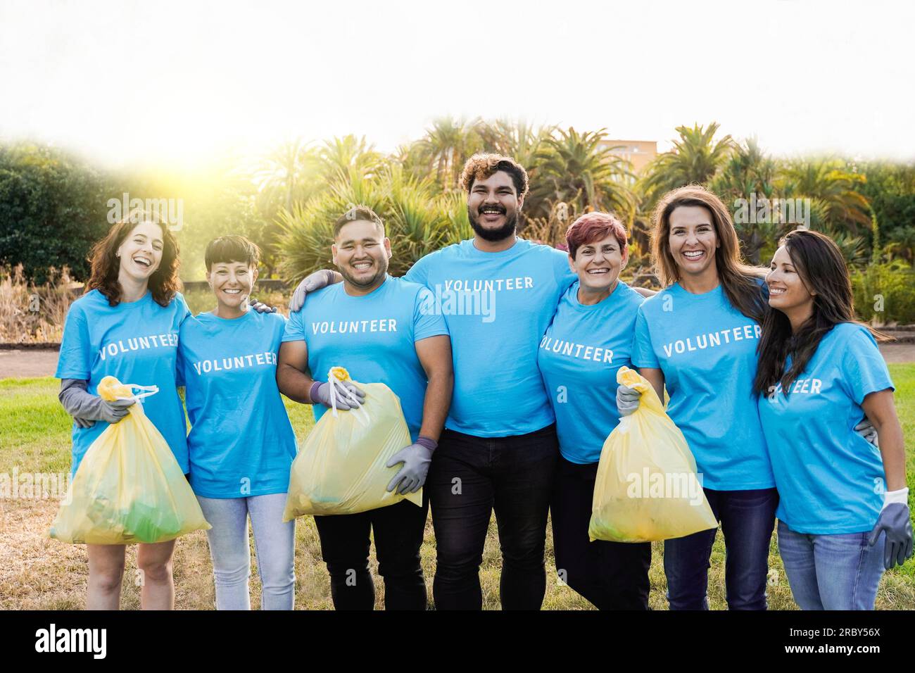 Happy volunteers helping community clean and recycle plastic at nature ...