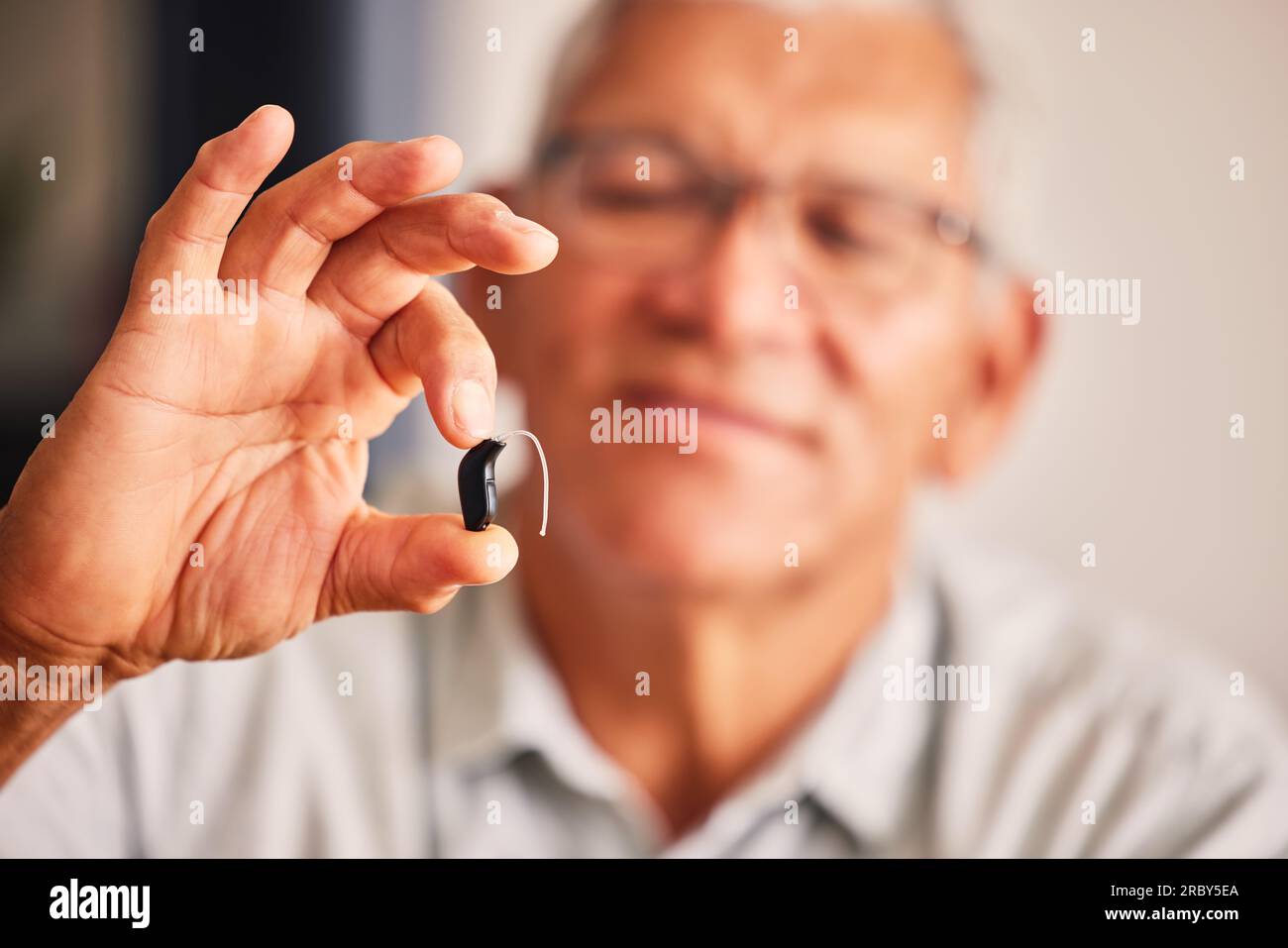 Hand holding hearing aid, senior man and tech for ears, health and ...