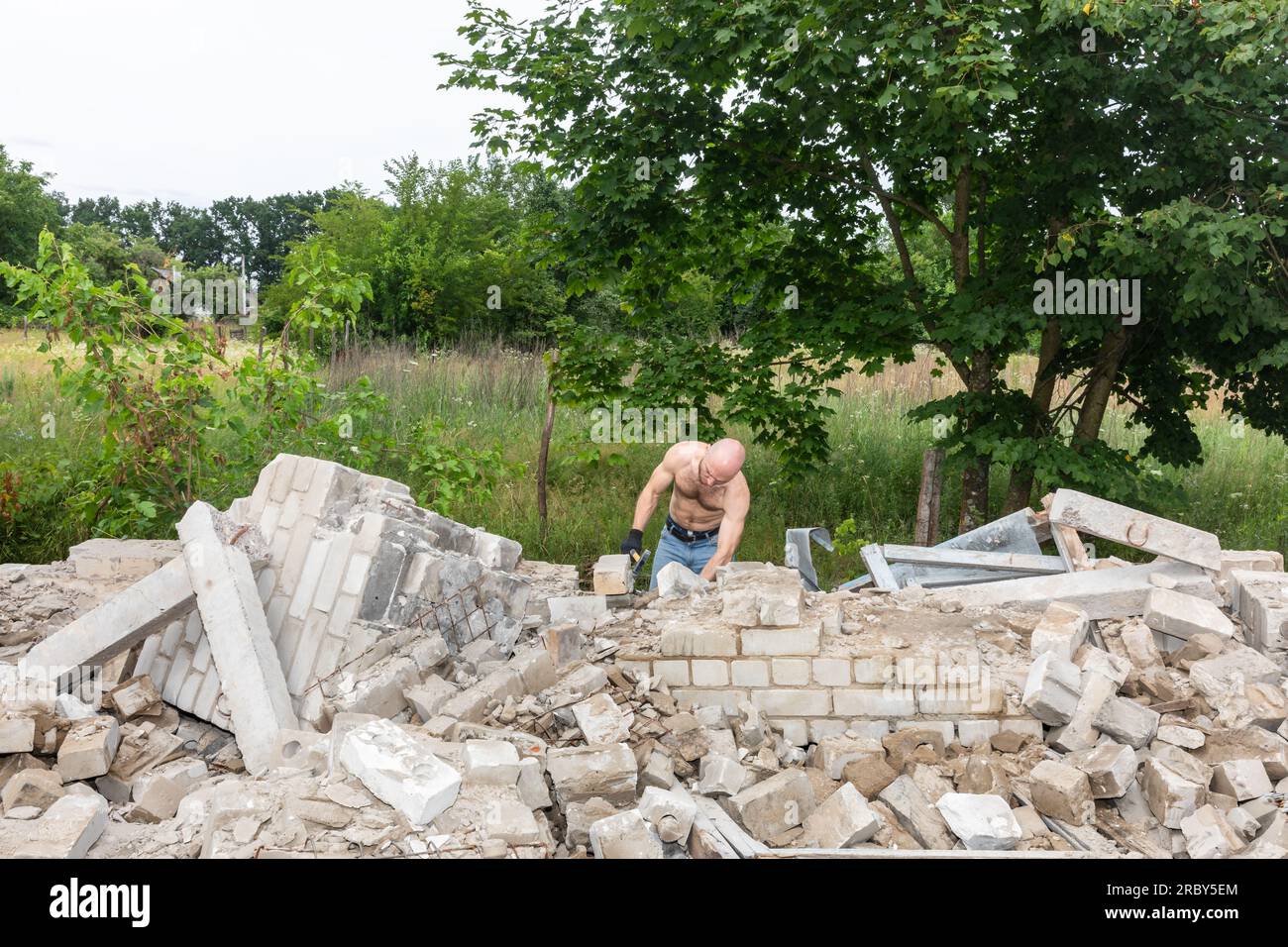 Young male volunteer of "Repair Together" charity organisation clears ...