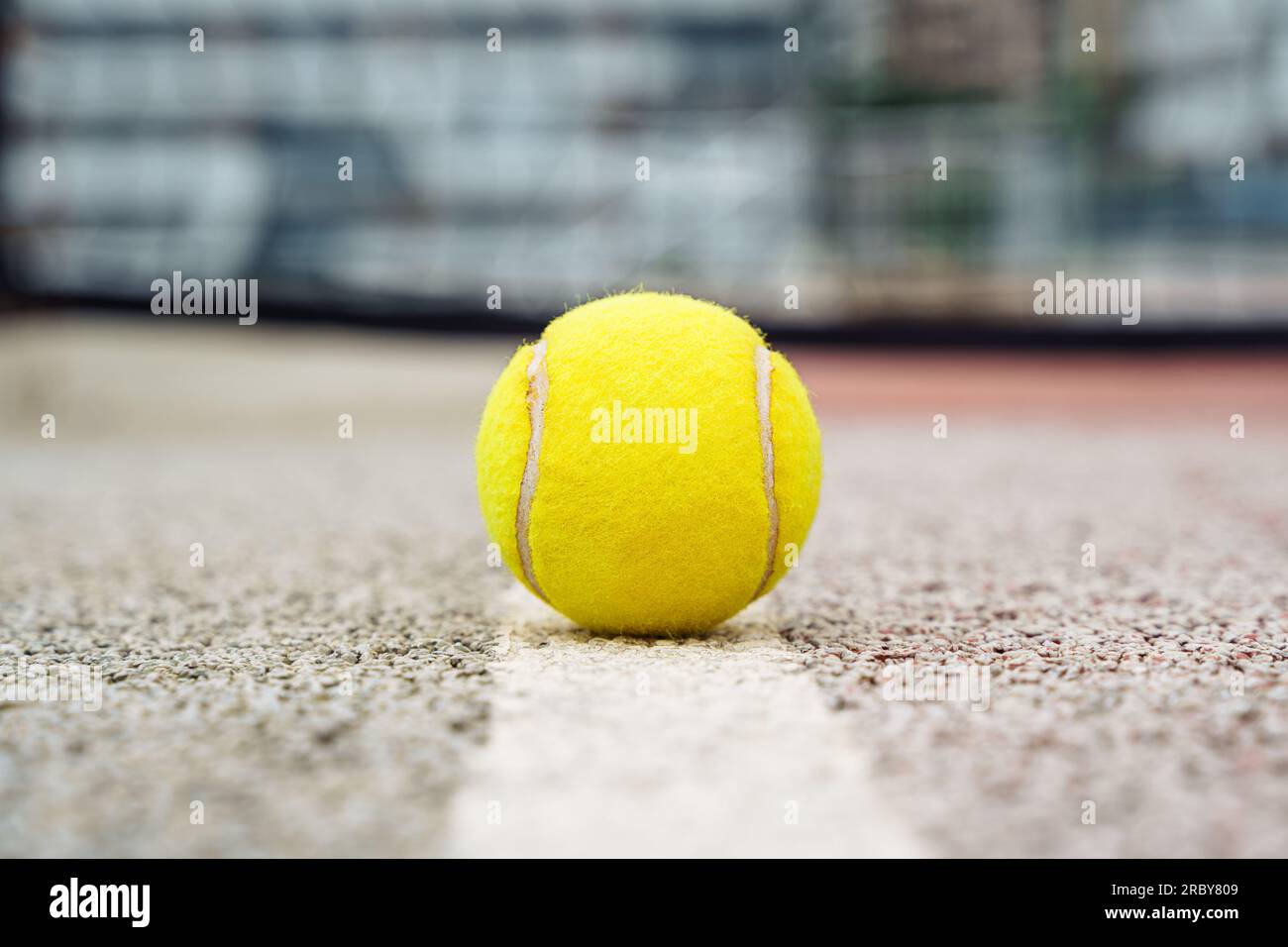 Closeup view of yellow tennis ball lying on acrylic tennis hard court ...